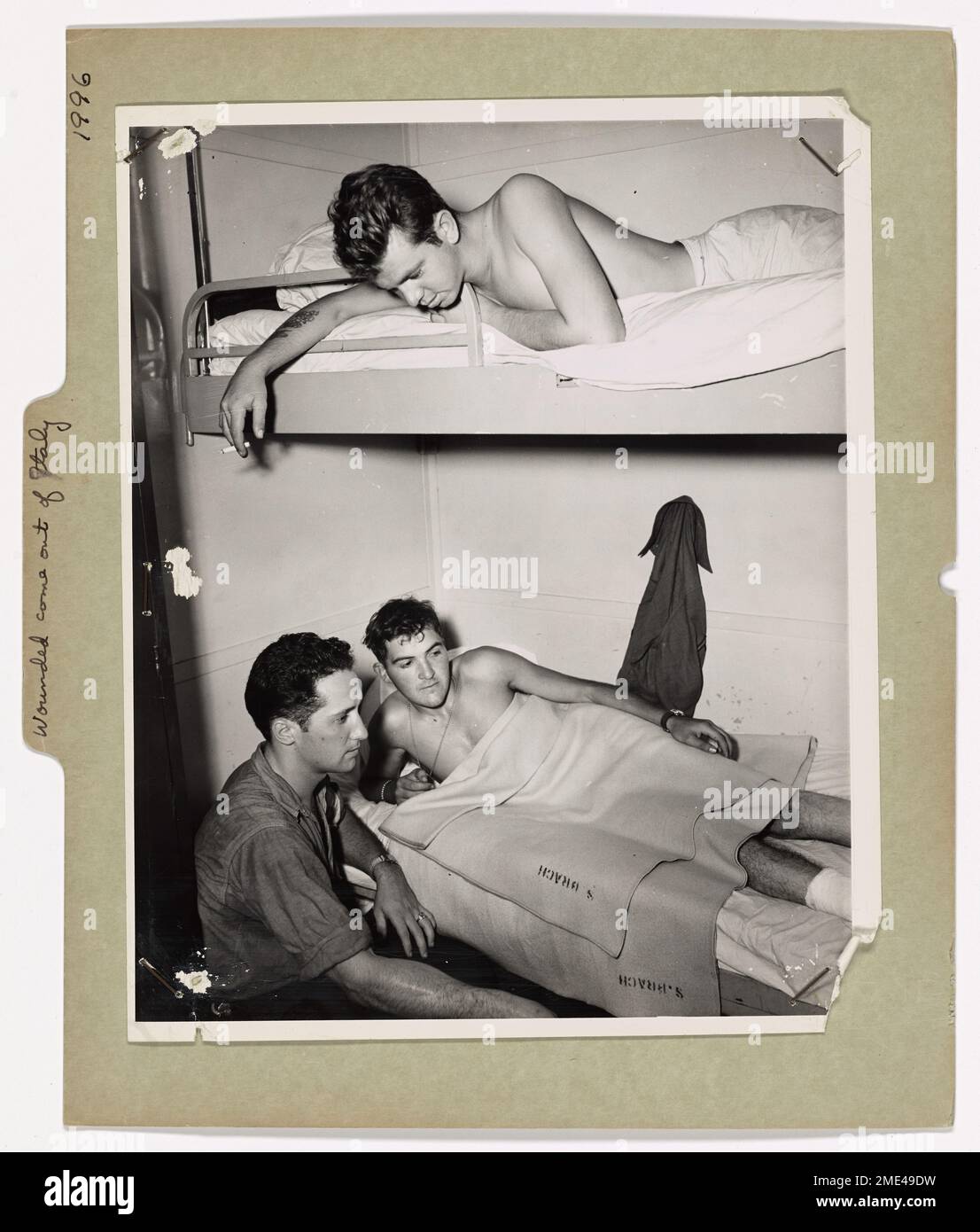 Two soldiers wounded during the Italian invasion are treated by Navy Pharmacist Mate Raymond ...