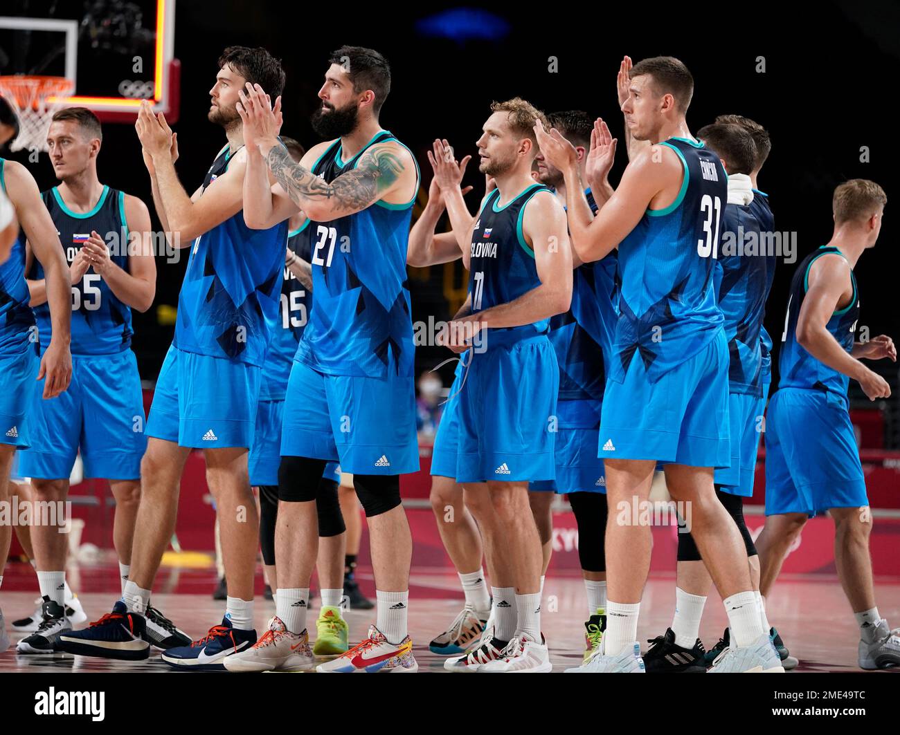 Slovenia players clap after their win in the men's basketball ...