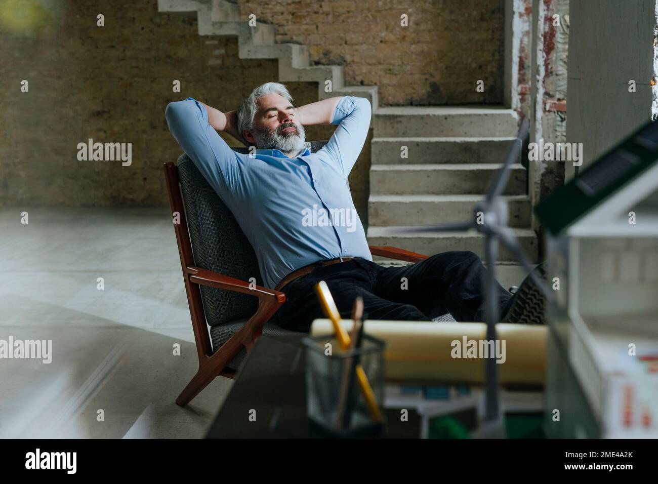 Architect relaxing in chair at under construction site Stock Photo - Alamy