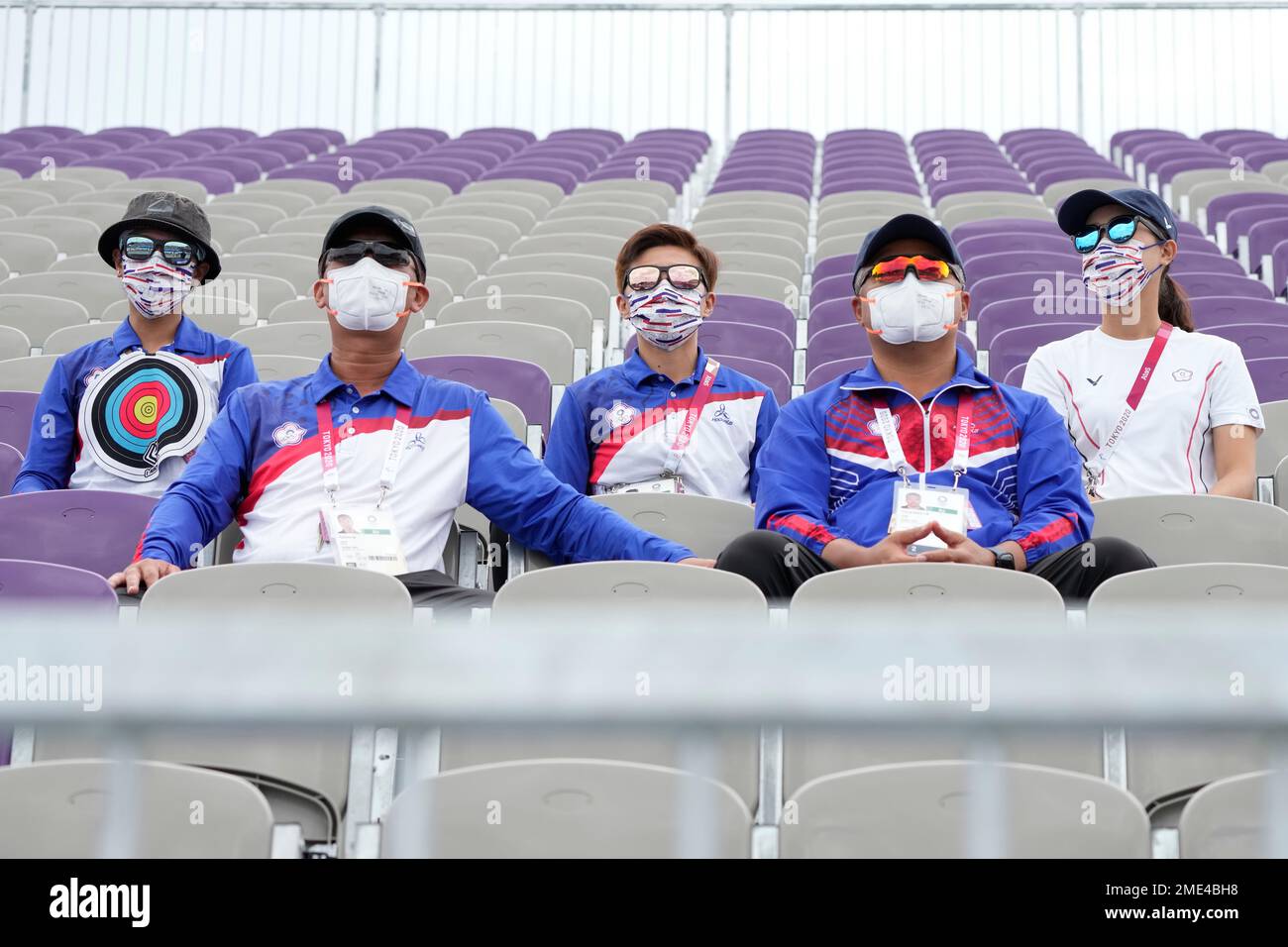 People sitting on the athletes' stand watch watch the men's team ...