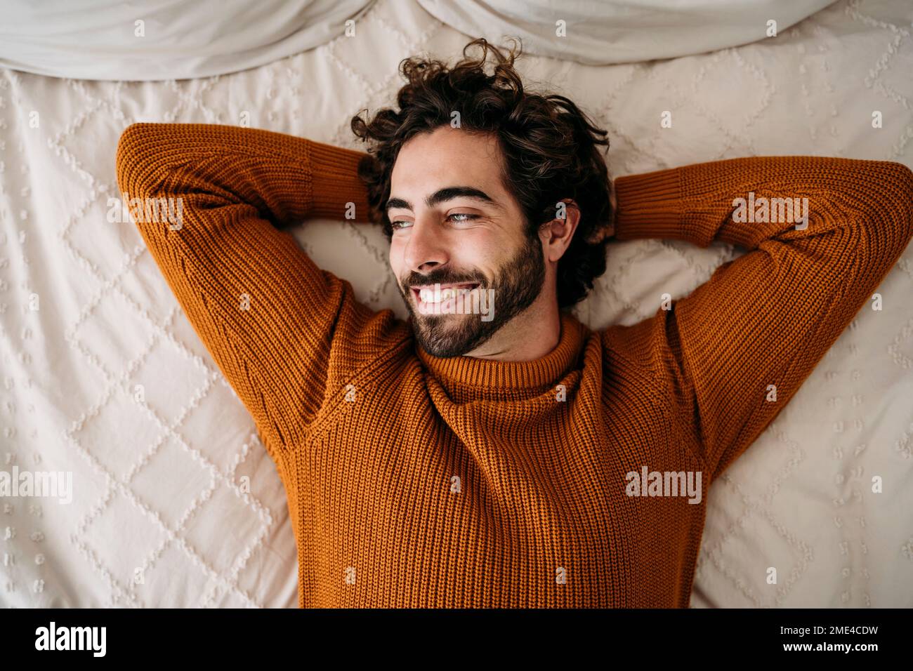 Happy young man relaxing on bed at home Stock Photo - Alamy