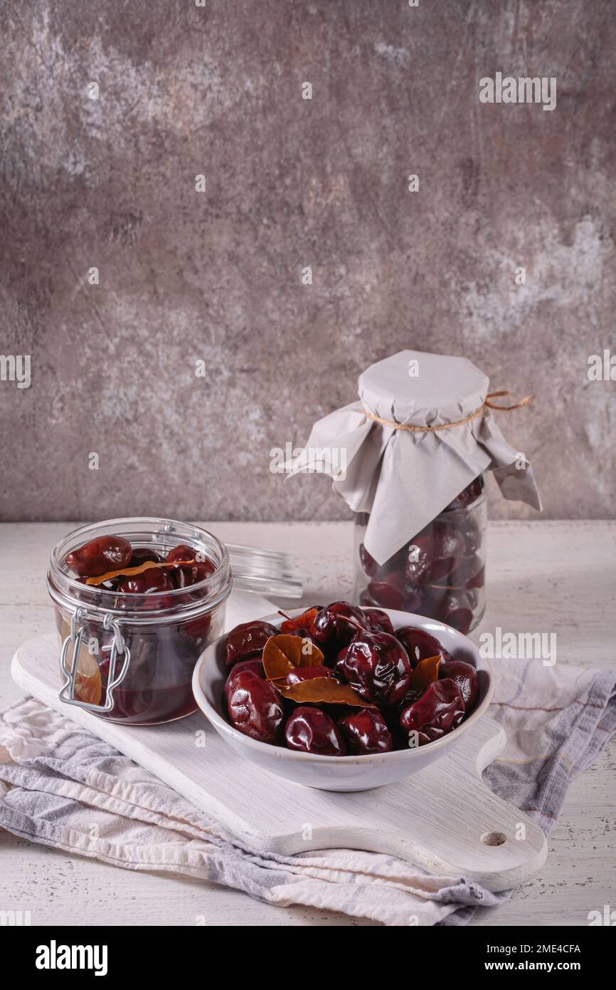 Marinated plums with spices in glass jar on the kitchen table Stock ...
