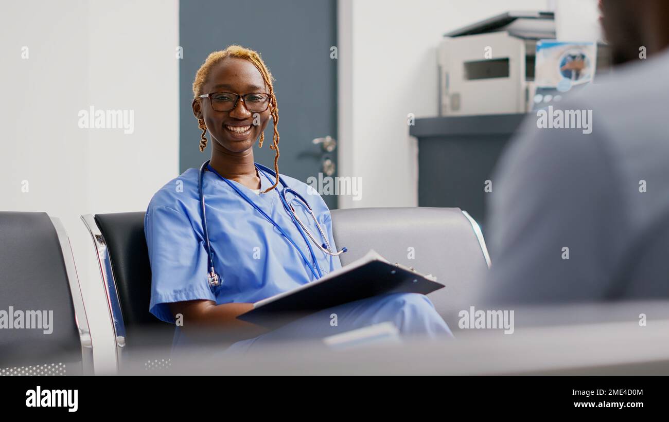 Medical assistant analyzing checkup reports in waiting lobby, sitting ...