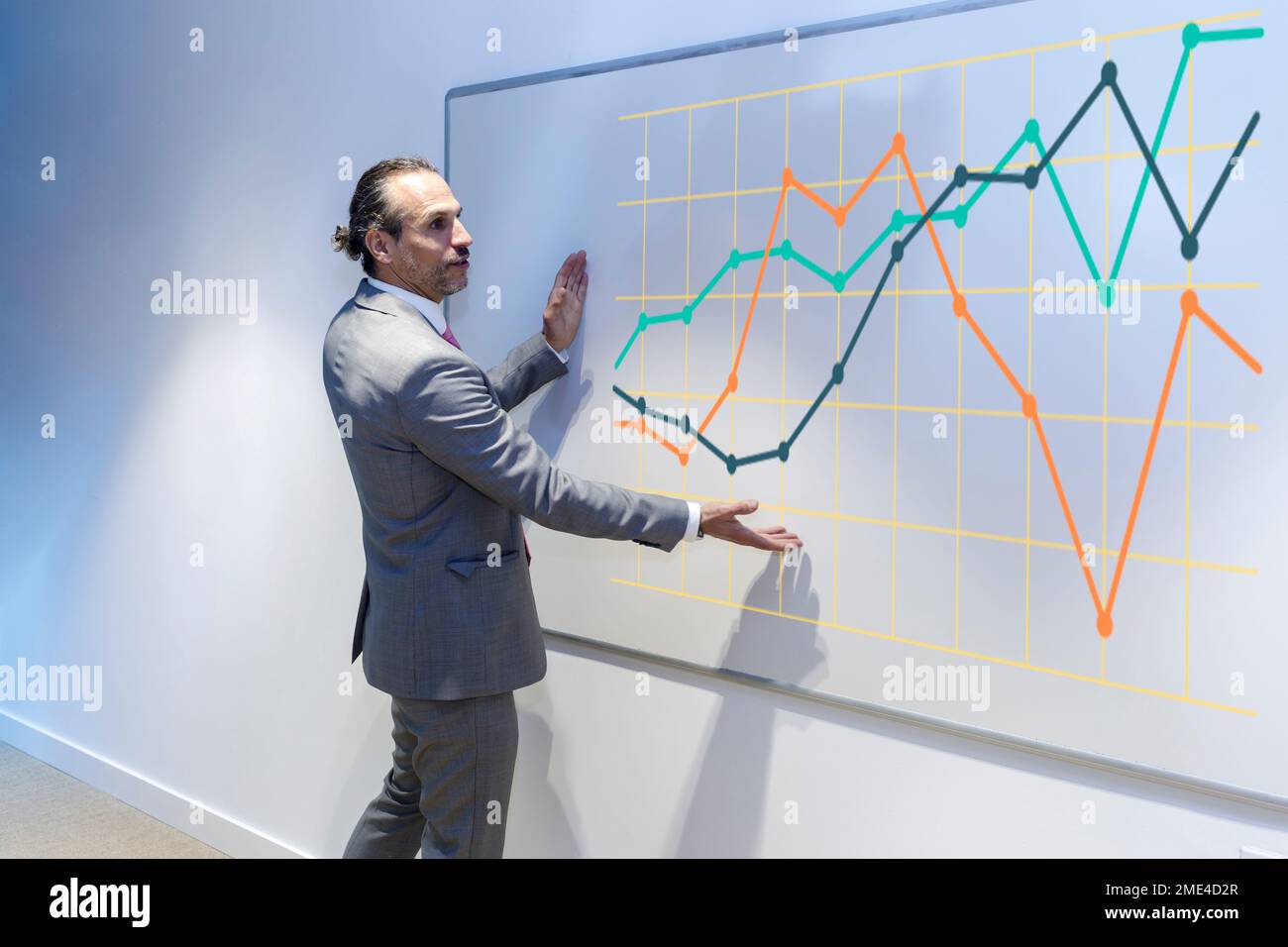 Businessman explaining graph on whiteboard in conference room Stock ...