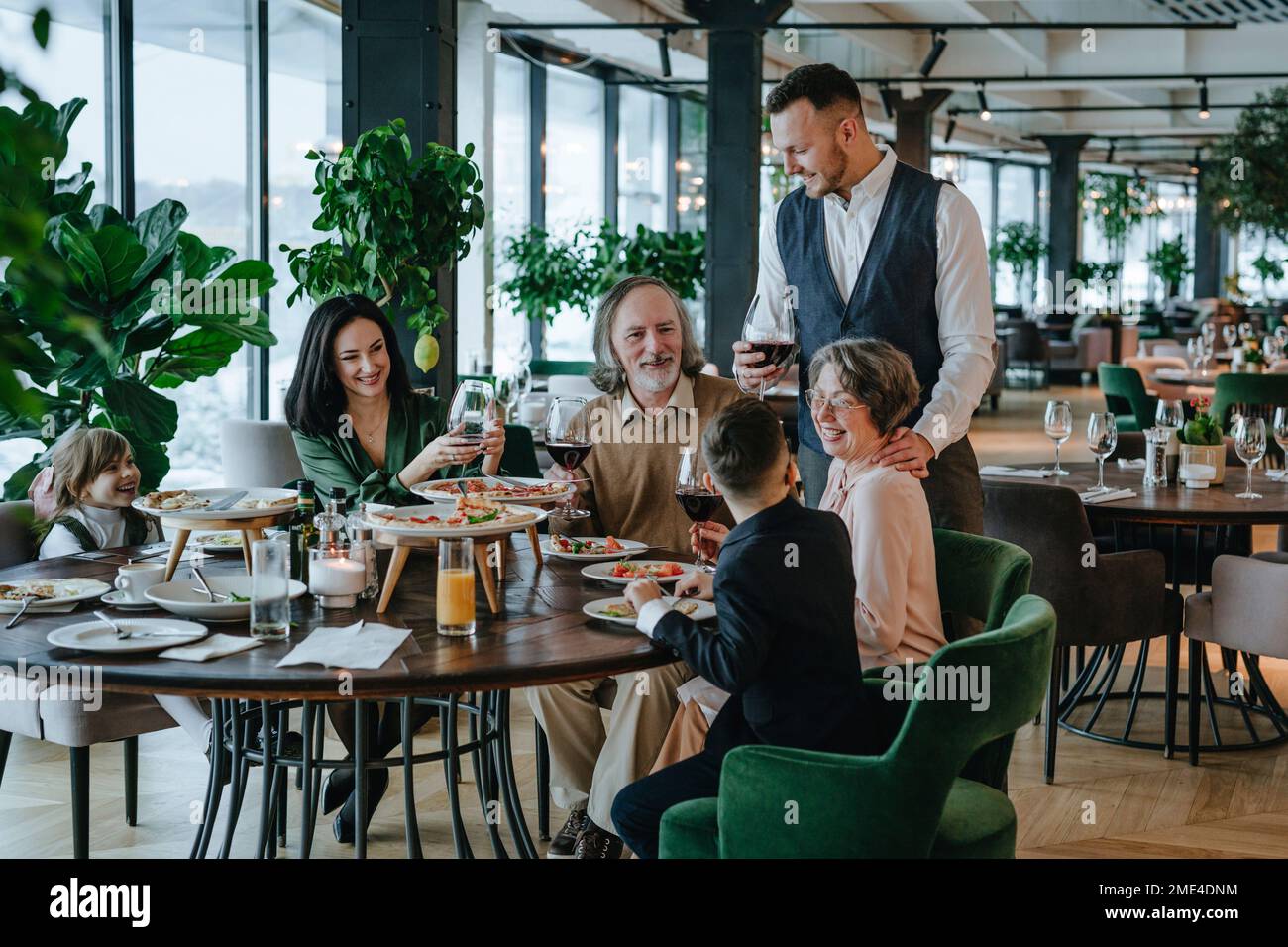Happy multi-generation family toasting wineglass at cafe Stock Photo ...