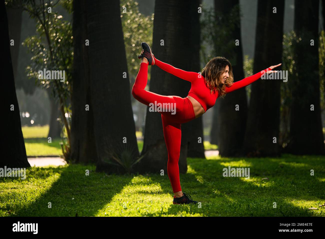 Woman with red colored yoga dress, posing yoga Natarajasana lord of the ...