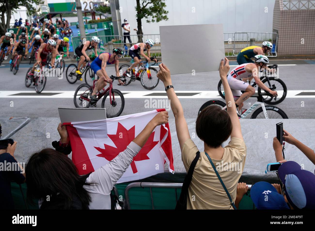 Spectators cheer athletes competing during the men's triathlon ...
