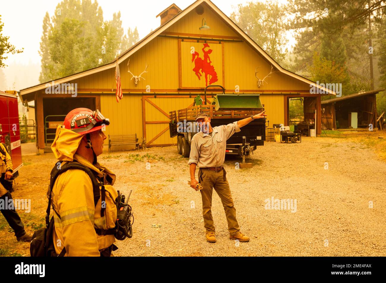Homeowner John Gleason speaks with firefighters as the Dixie Fire ...