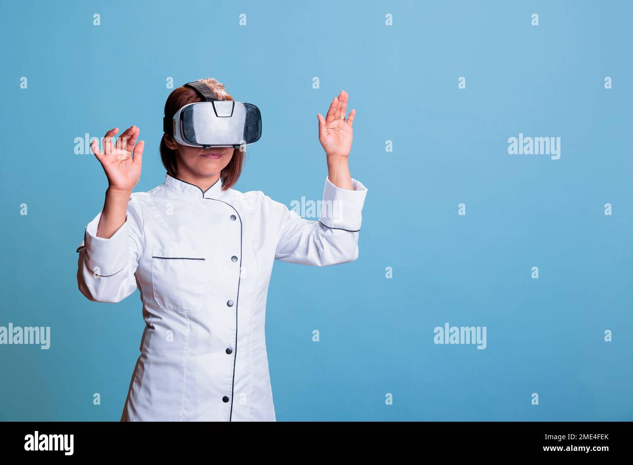 Friendly cook worker using virtual reality goggles while cooking ...