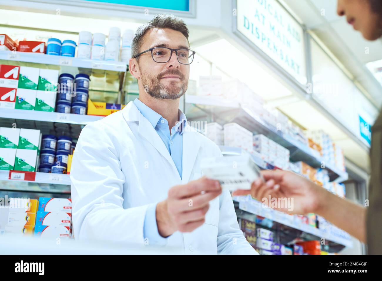 Your medication. a handsome mature male pharmacist helping a female ...