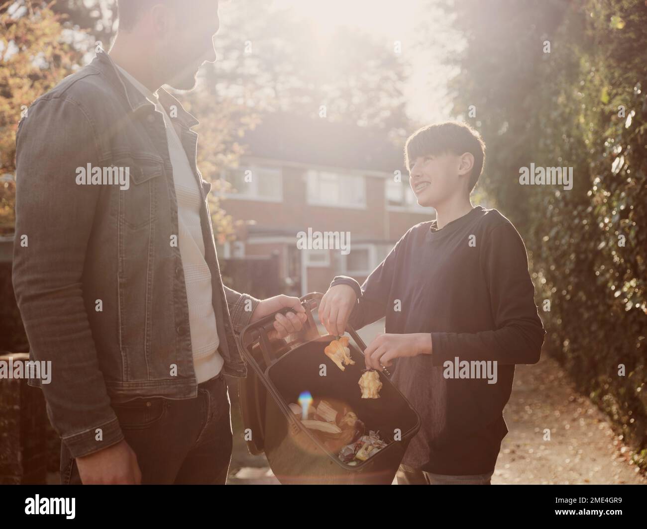 Father and son carrying compost bucket Stock Photo - Alamy