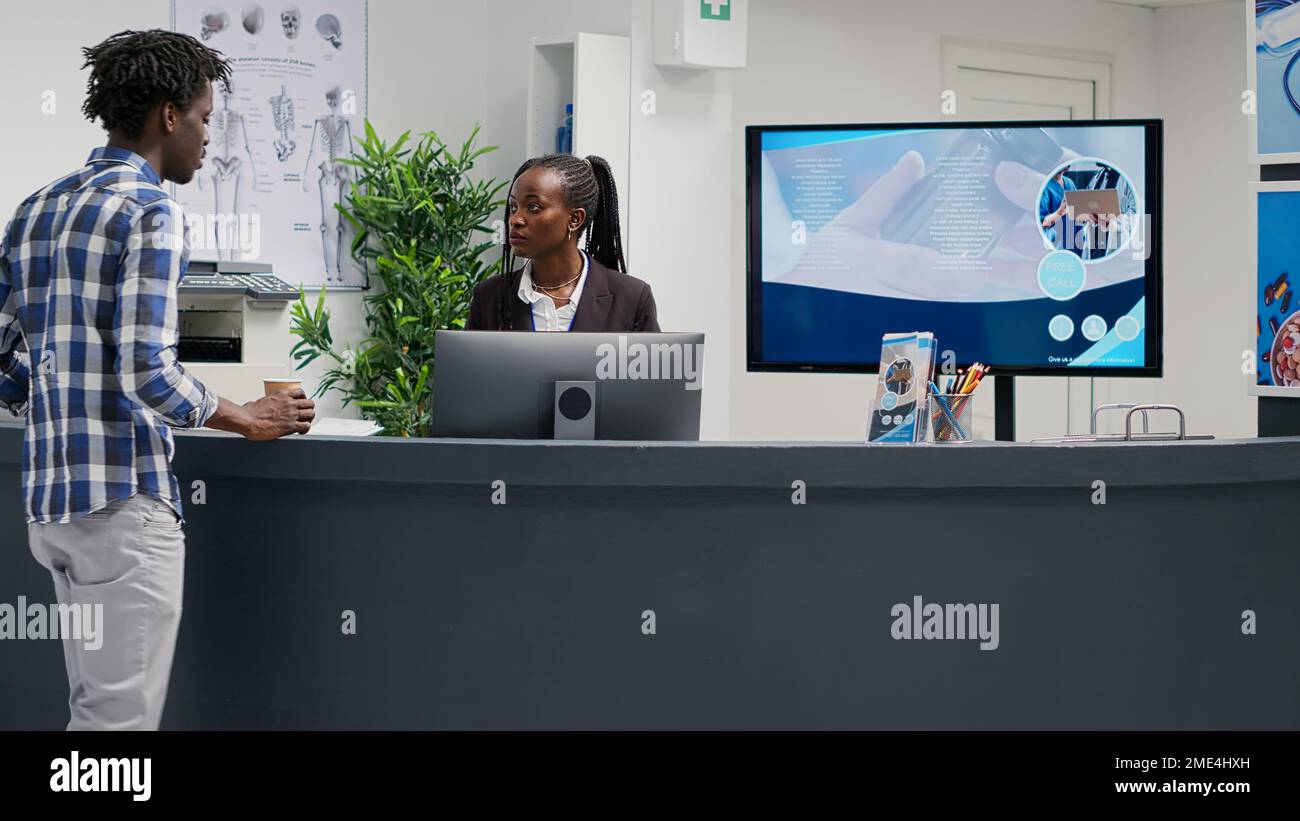 Female employee helping person with checkup report, explaining to fill ...