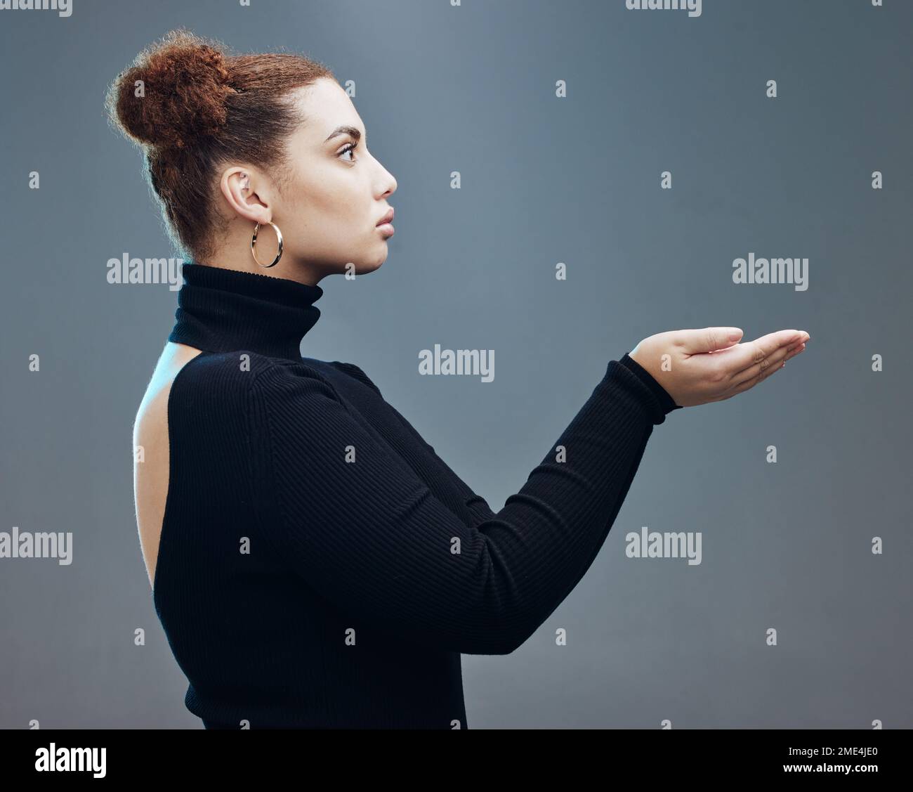 Hand, woman and holding gesture in studio with mockup, space and grey ...