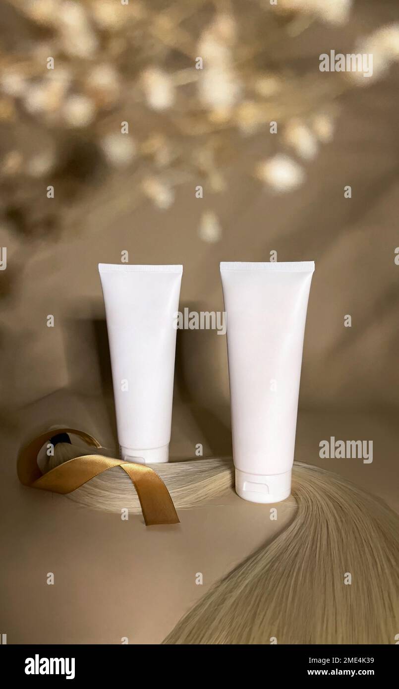 A strand of natural light hair for extensions with a bottle of care ...