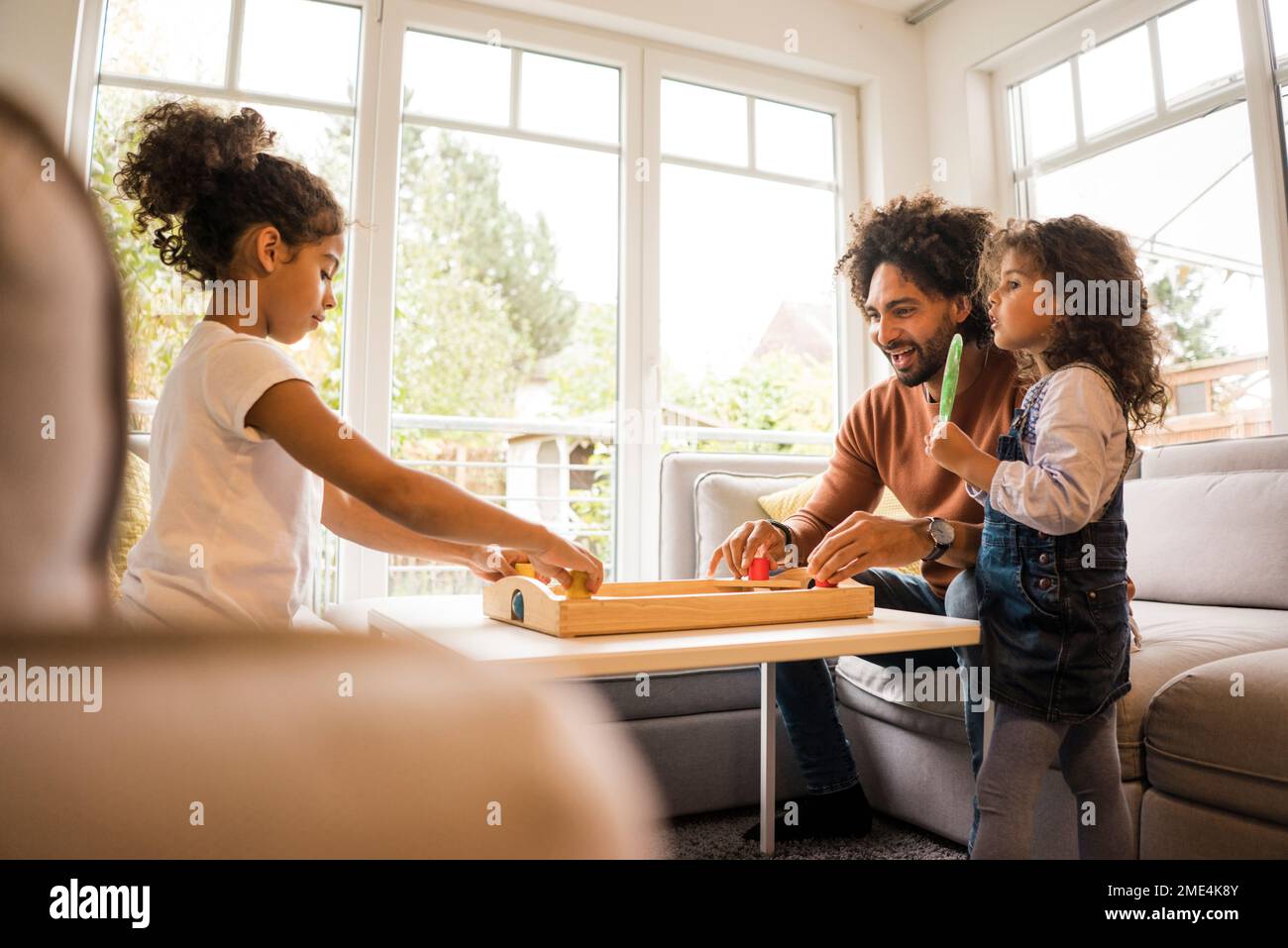Happy father playing board games with daughters at home Stock Photo - Alamy