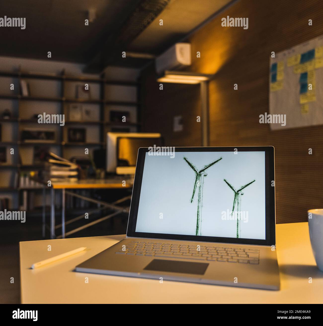 Laptop with wind turbines on screen kept at desk Stock Photo - Alamy