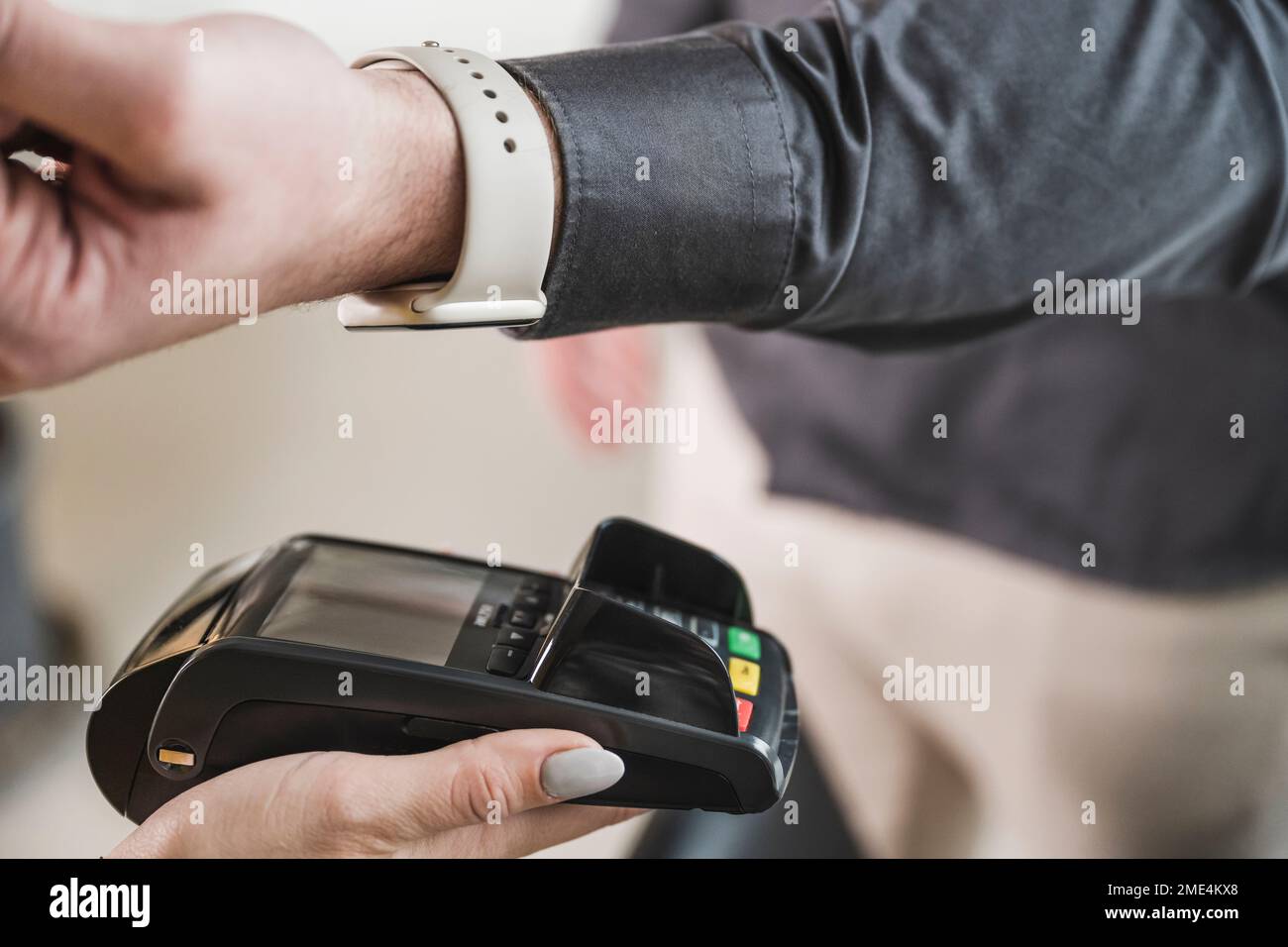 Hand of young businessman paying with smart watch Stock Photo - Alamy