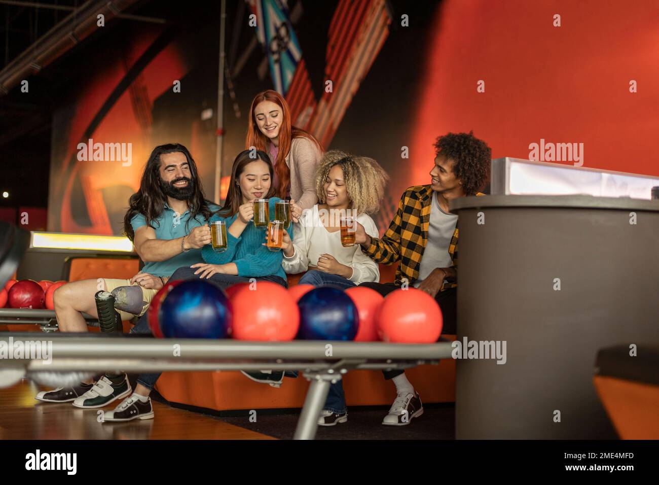 Multiracial friends having beer at sofa in bowling alley Stock Photo ...