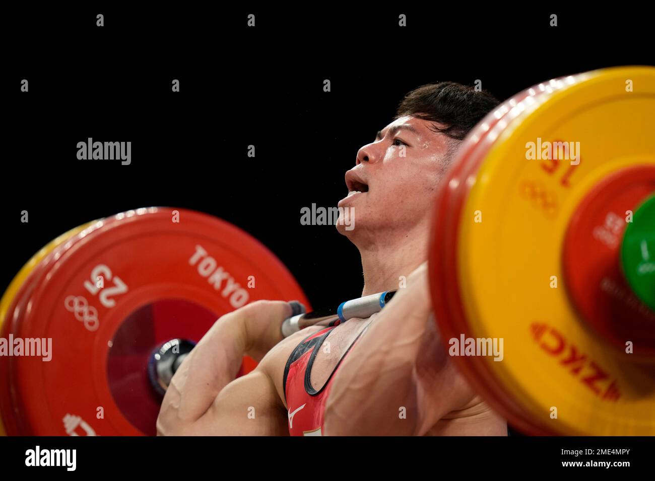 Itokazu Yoichi of Japan competes in the men's 61kg weightlifting event ...