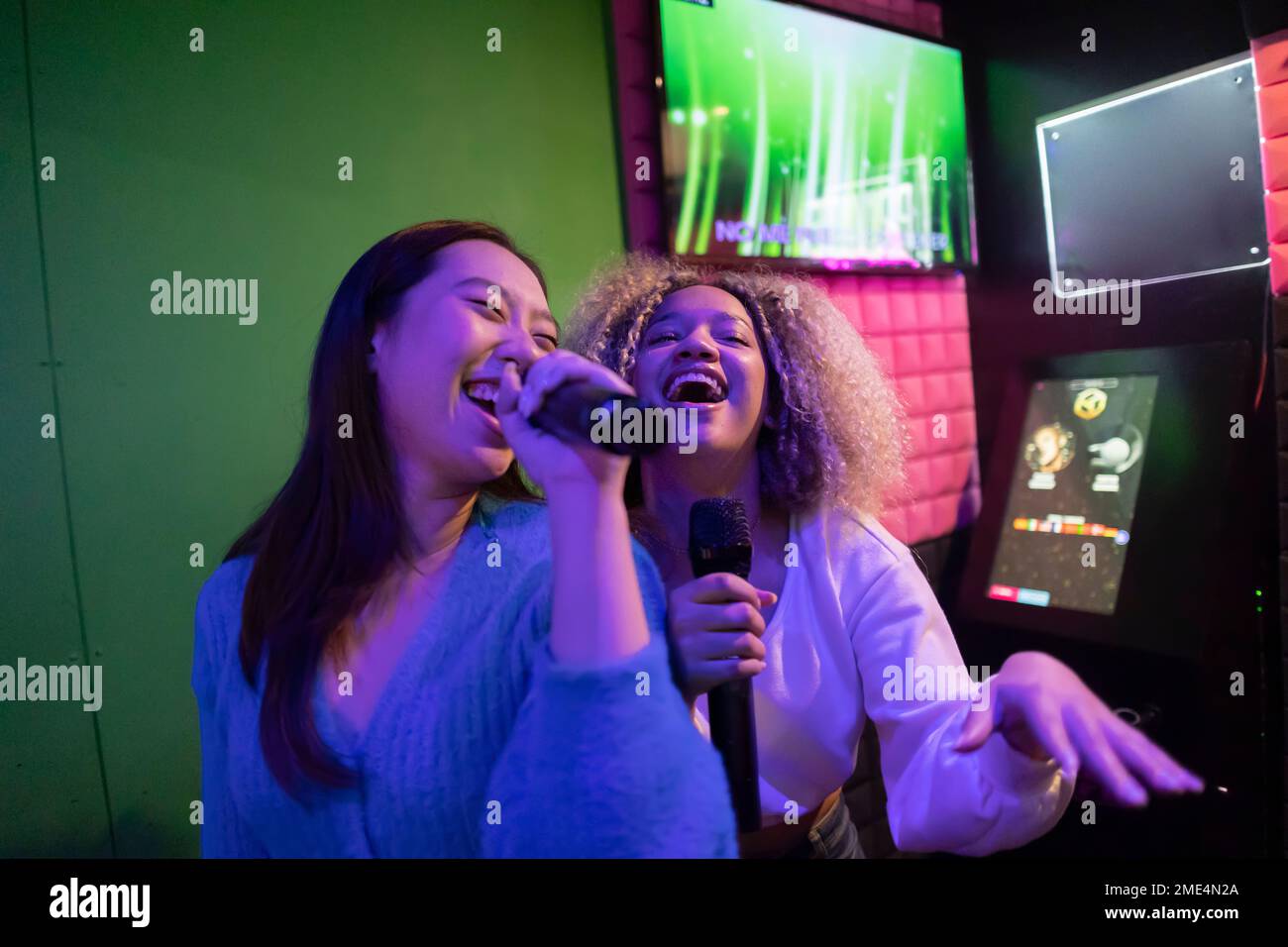 Cheerful young adults singing karaoke hi-res stock photography and ...