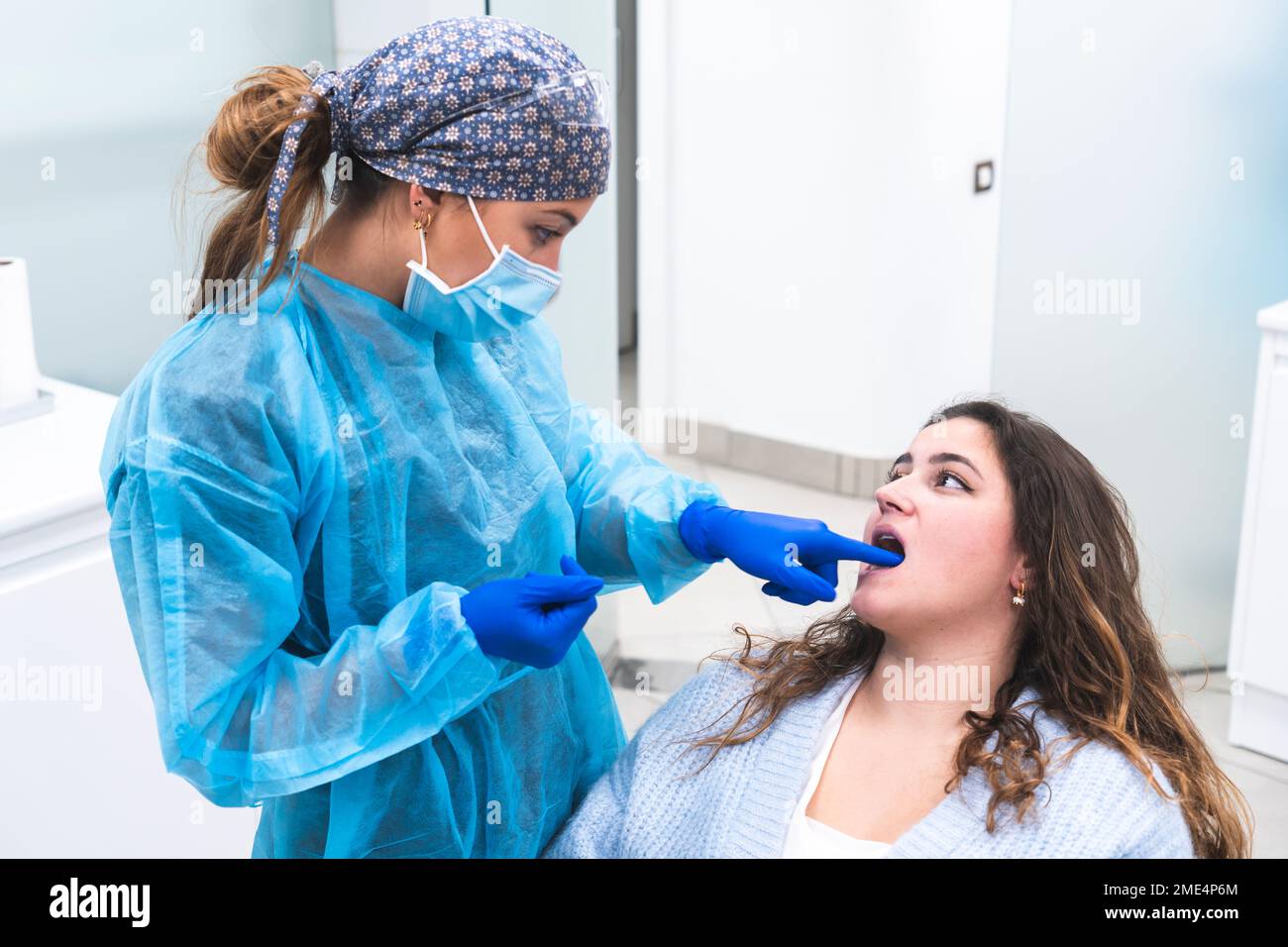 Dentist examining teeth of woman at clinic Stock Photo - Alamy
