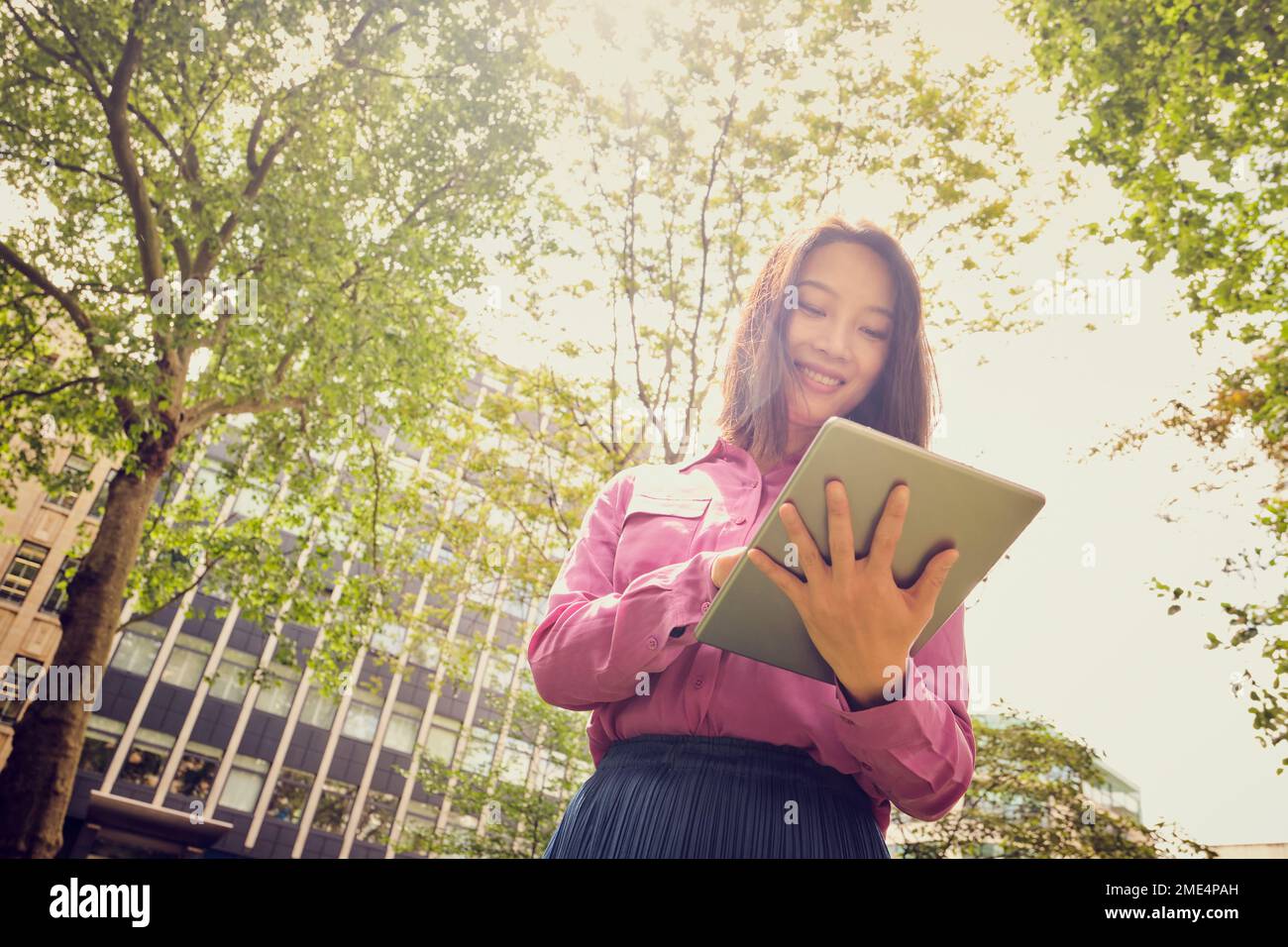 Happy businesswoman using tablet PC on sunny day Stock Photo - Alamy