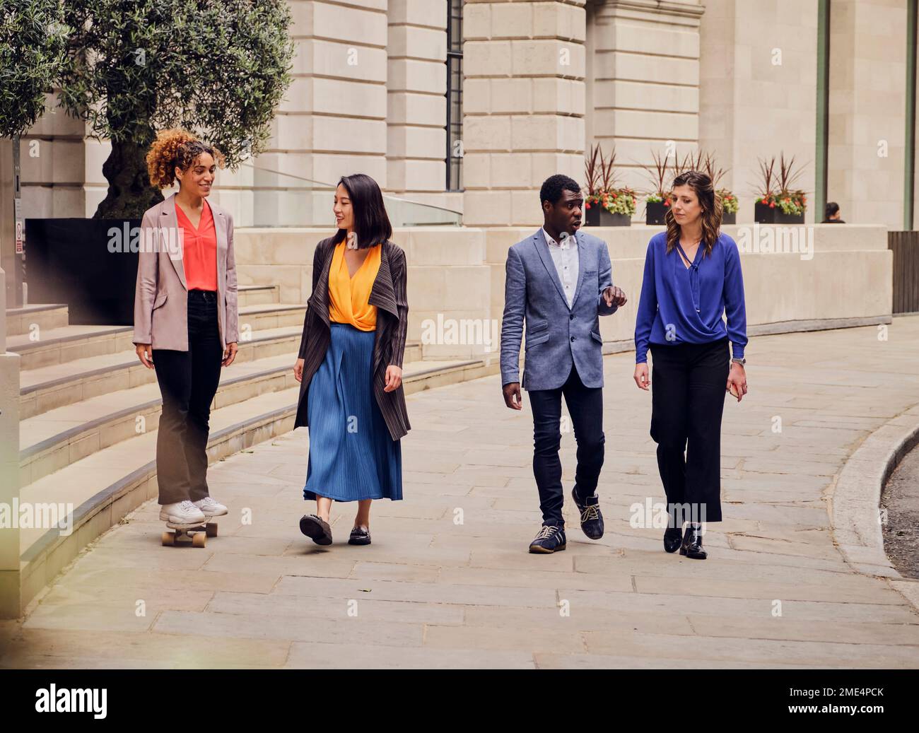 Businessman walking with colleagues and having discussion on footpath ...