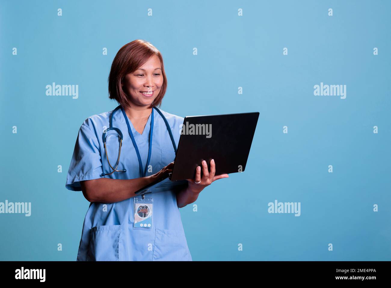 Practitioner nurse holding laptop computer checking medical ...