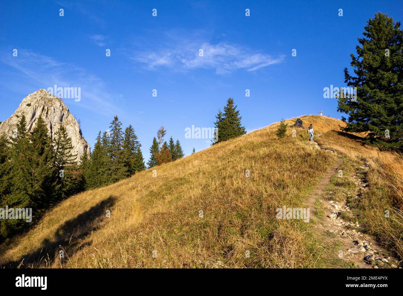 Man hiking on mountain through narrow footpath under blue sky Stock ...