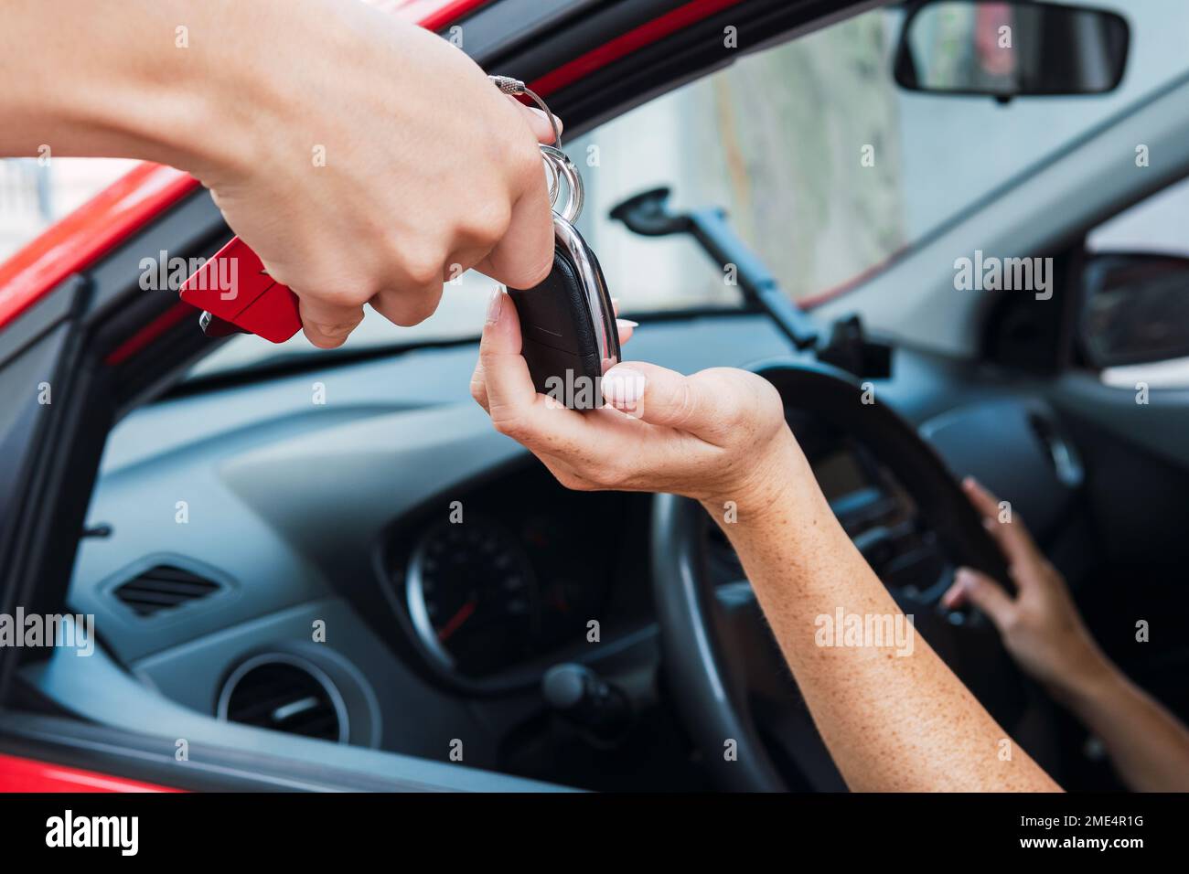 Salesman handling keys to customer Stock Photo - Alamy