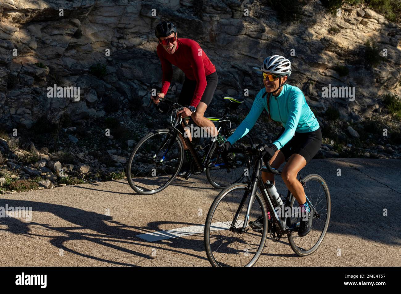 Happy cyclists riding bicycles on road Stock Photo - Alamy