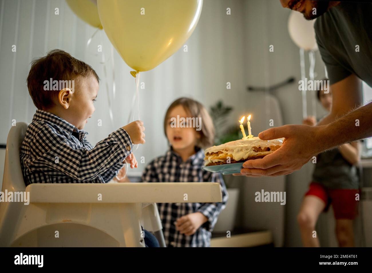 Father holding cake and celebrating son's birthday at home Stock Photo ...
