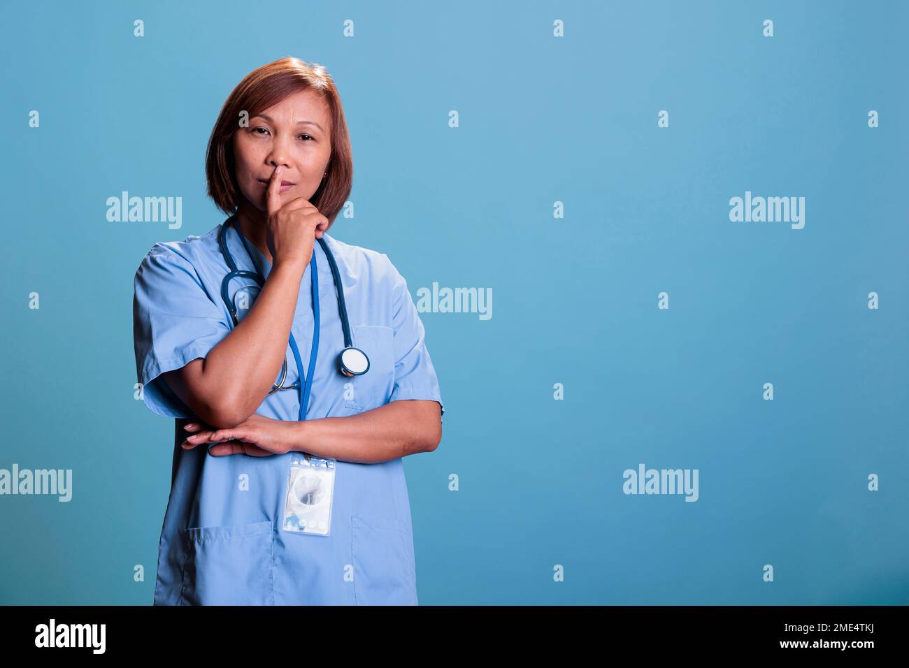 Pensive medical assistant wearing blue uniform thinking about health ...