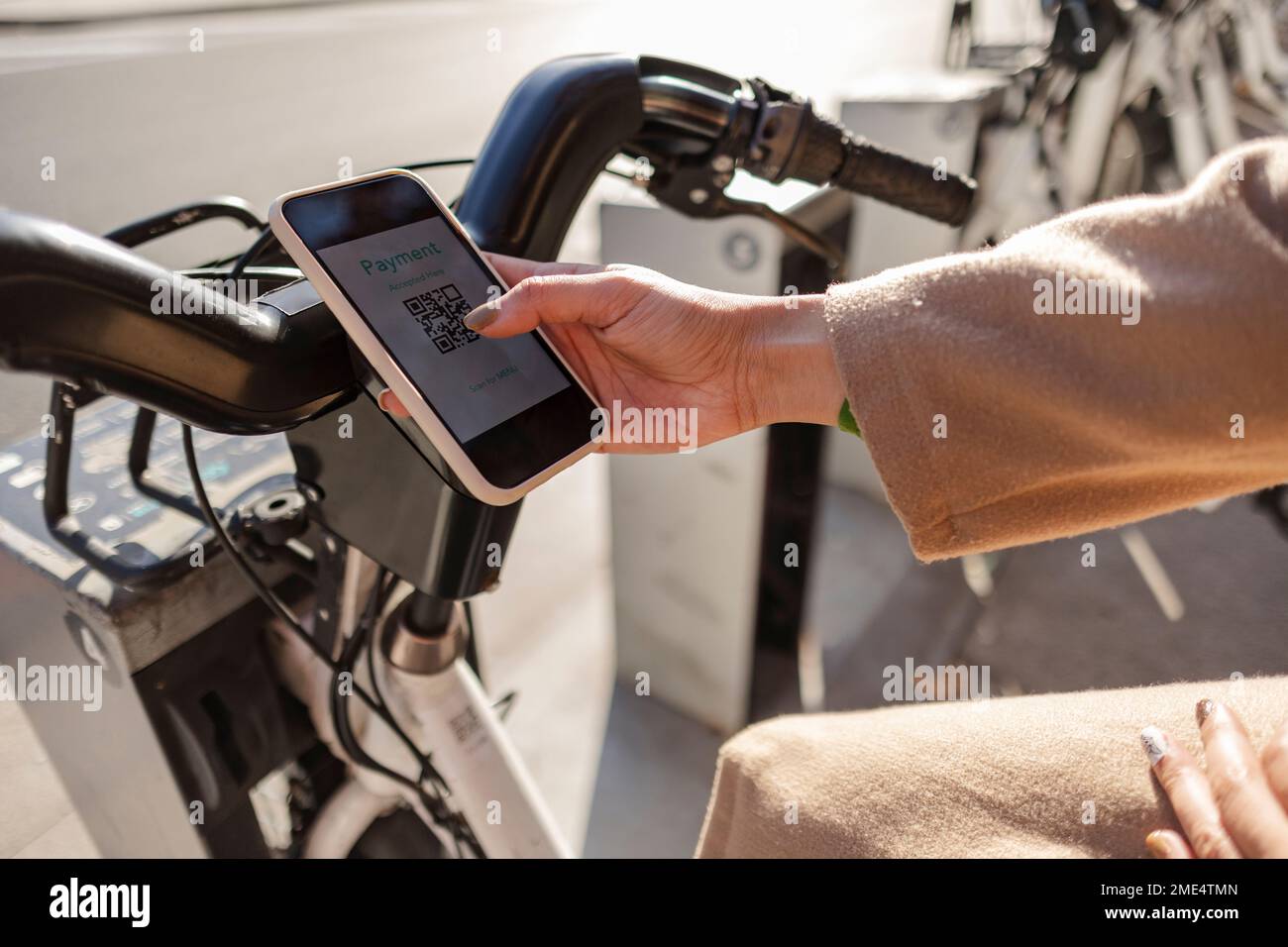 Young woman scanning QR code for renting bicycle Stock Photo - Alamy