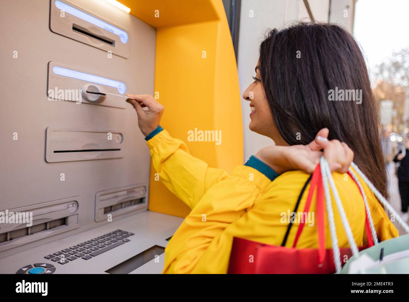 Woman inserting card into ATM machine Stock Photo - Alamy