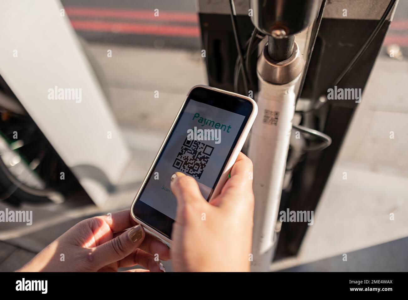 Young woman scanning QR code for renting bicycle Stock Photo - Alamy