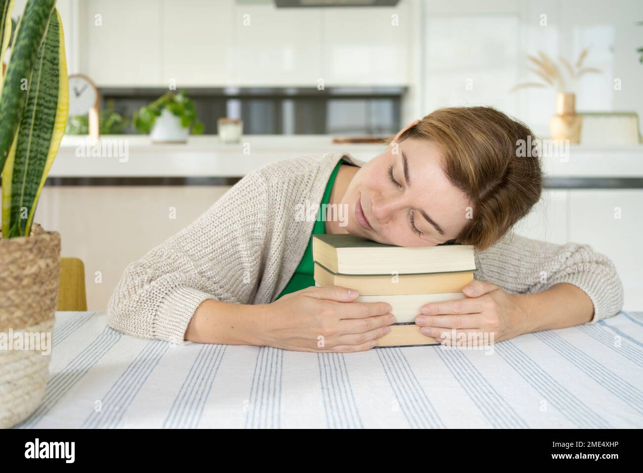 Woman resting on stack of books at home Stock Photo - Alamy
