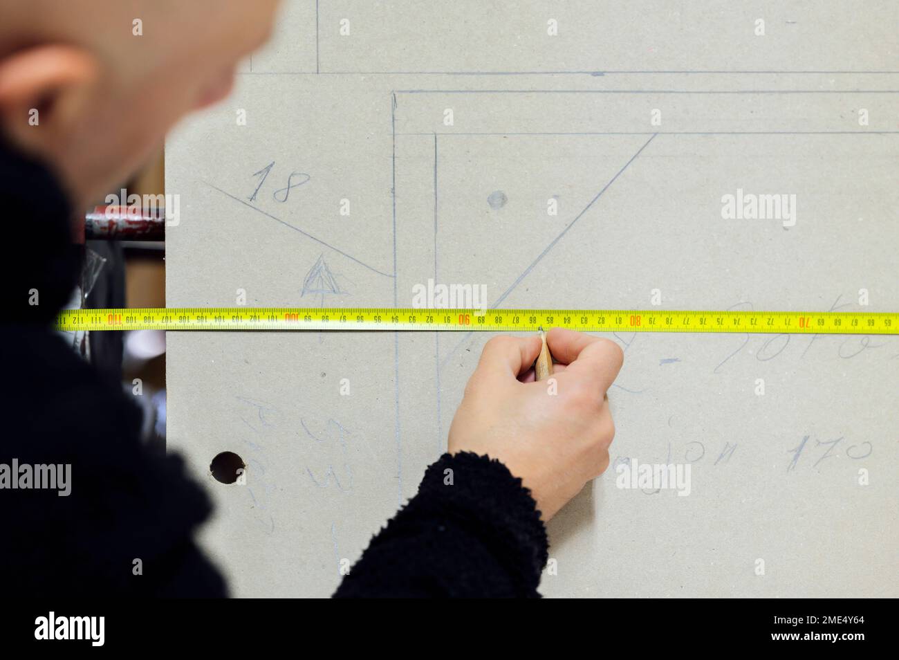 Upholsterer using measuring tape in workshop Stock Photo - Alamy