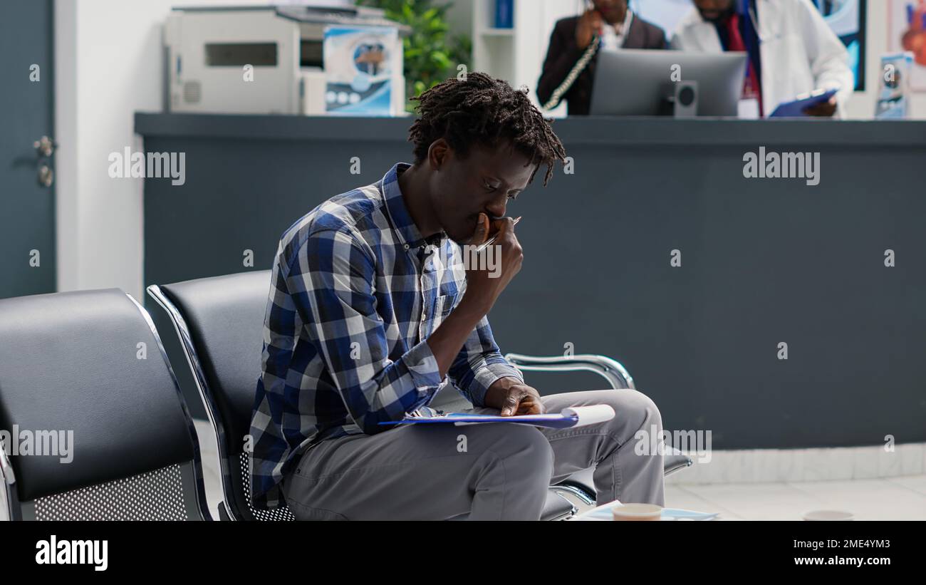 African american man filling in checkup report papers on clipboard ...