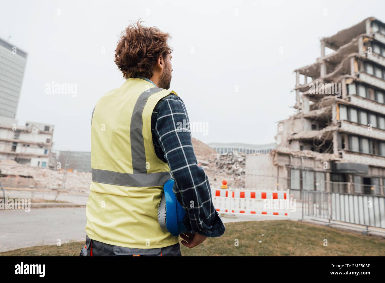 Blue-collar worker looking at construction site Stock Photo - Alamy