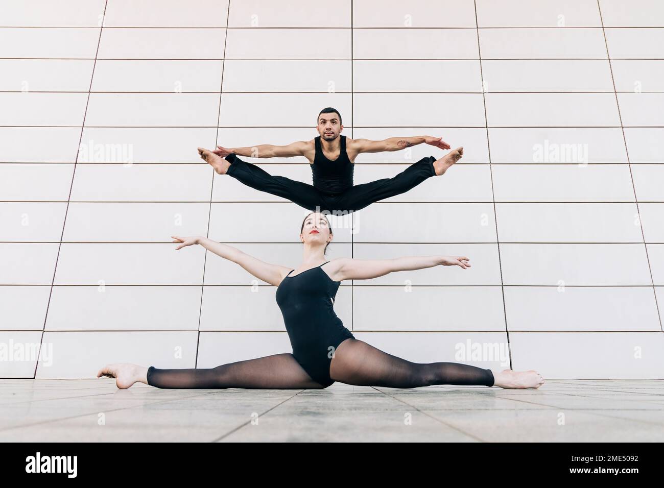 Couple dancing with legs apart in front of wall Stock Photo - Alamy