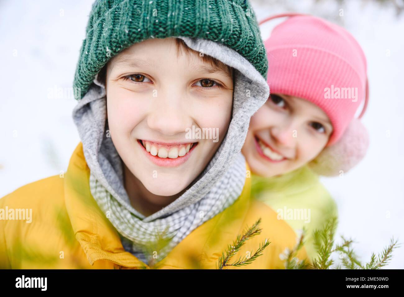 Happy brother and sister wearing knit hats in snow Stock Photo - Alamy