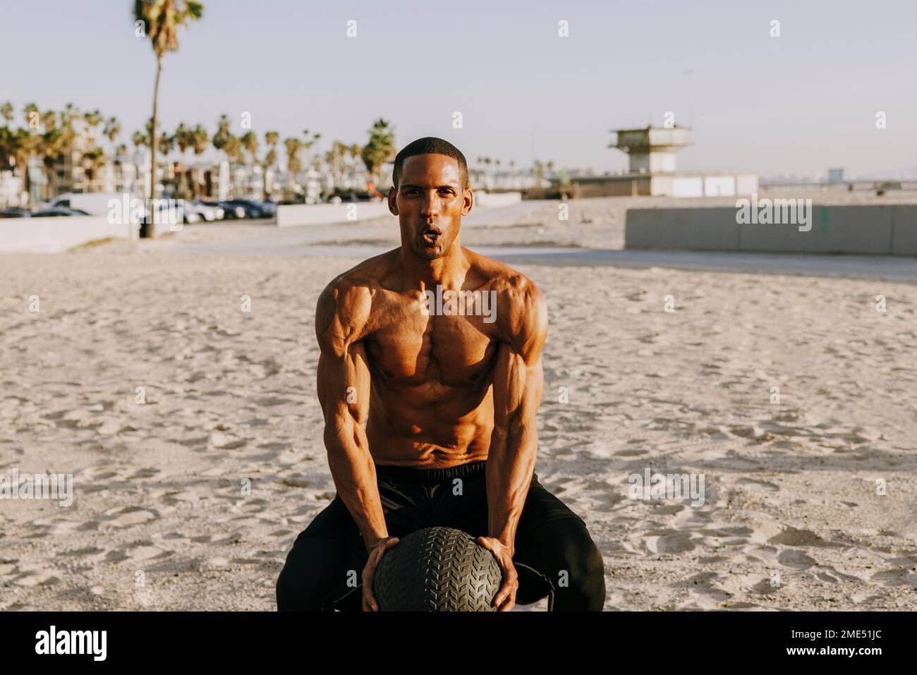Active man exercising with sports ball on beach Stock Photo - Alamy