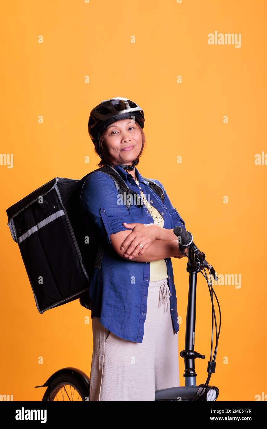 Smiling takeaway delivery person carrying thermal takeout food backpack ...