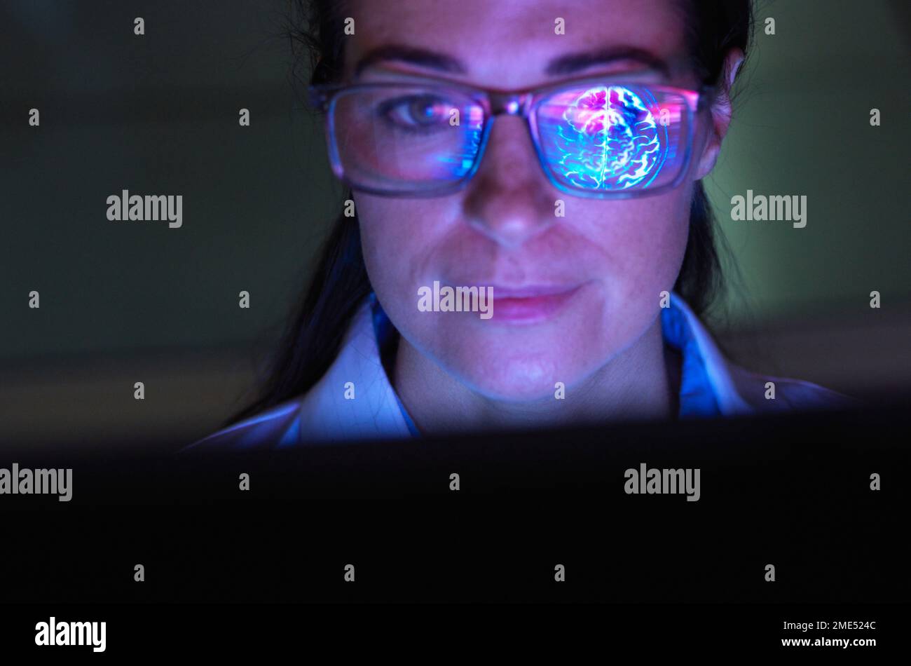 Scan of the human brain reflected in researching doctor's eyeglasses ...
