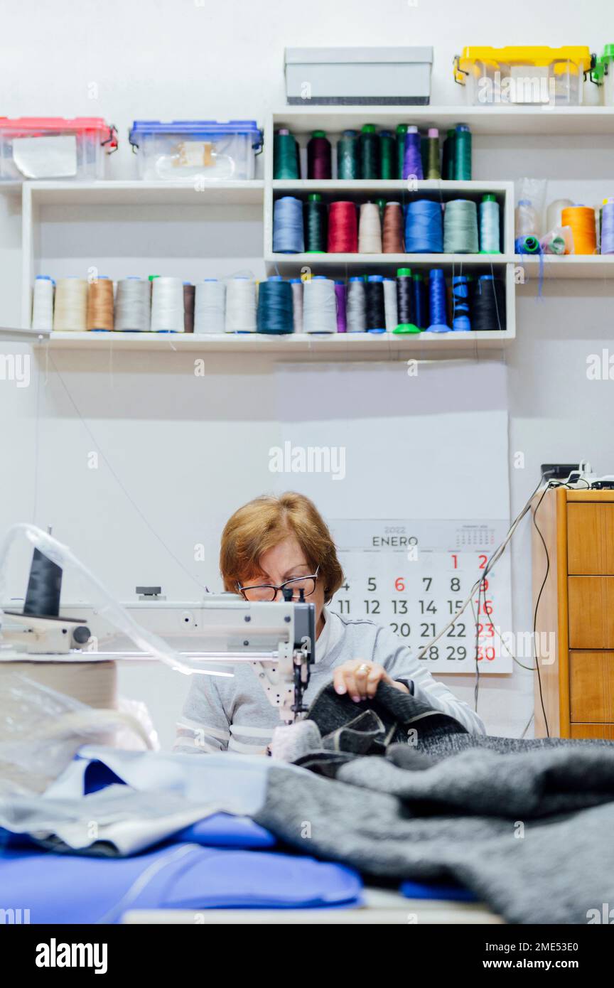 Woman sewing fabric in upholstery workshop Stock Photo - Alamy