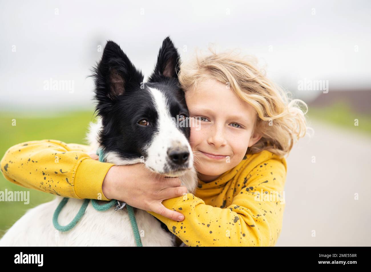 Smiling blond boy hugging Border Collie dog Stock Photo - Alamy