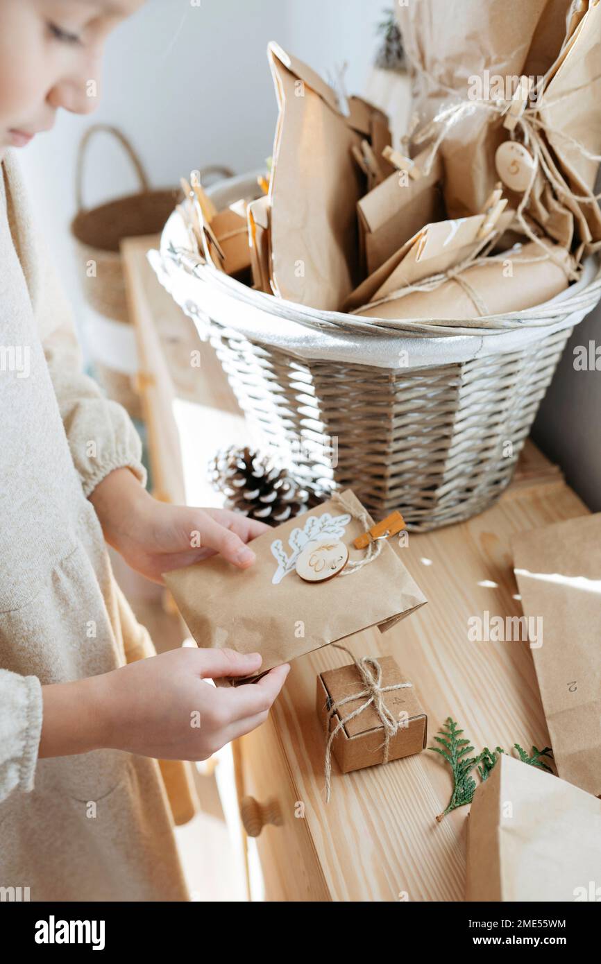 Girl looking at gifts from advent calendar at home Stock Photo - Alamy