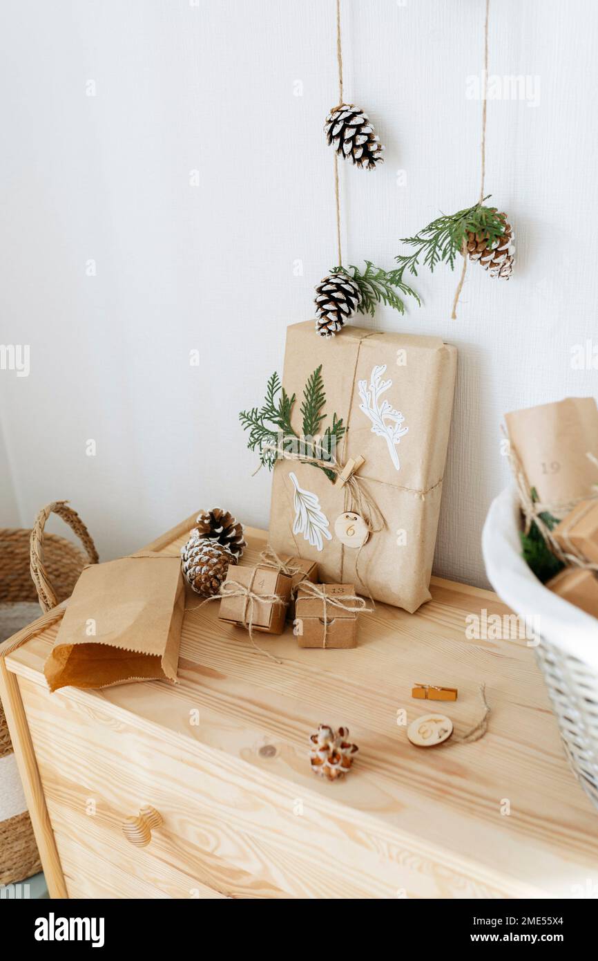 Christmas gift boxes with decorated pine cones kept on cabinet Stock ...