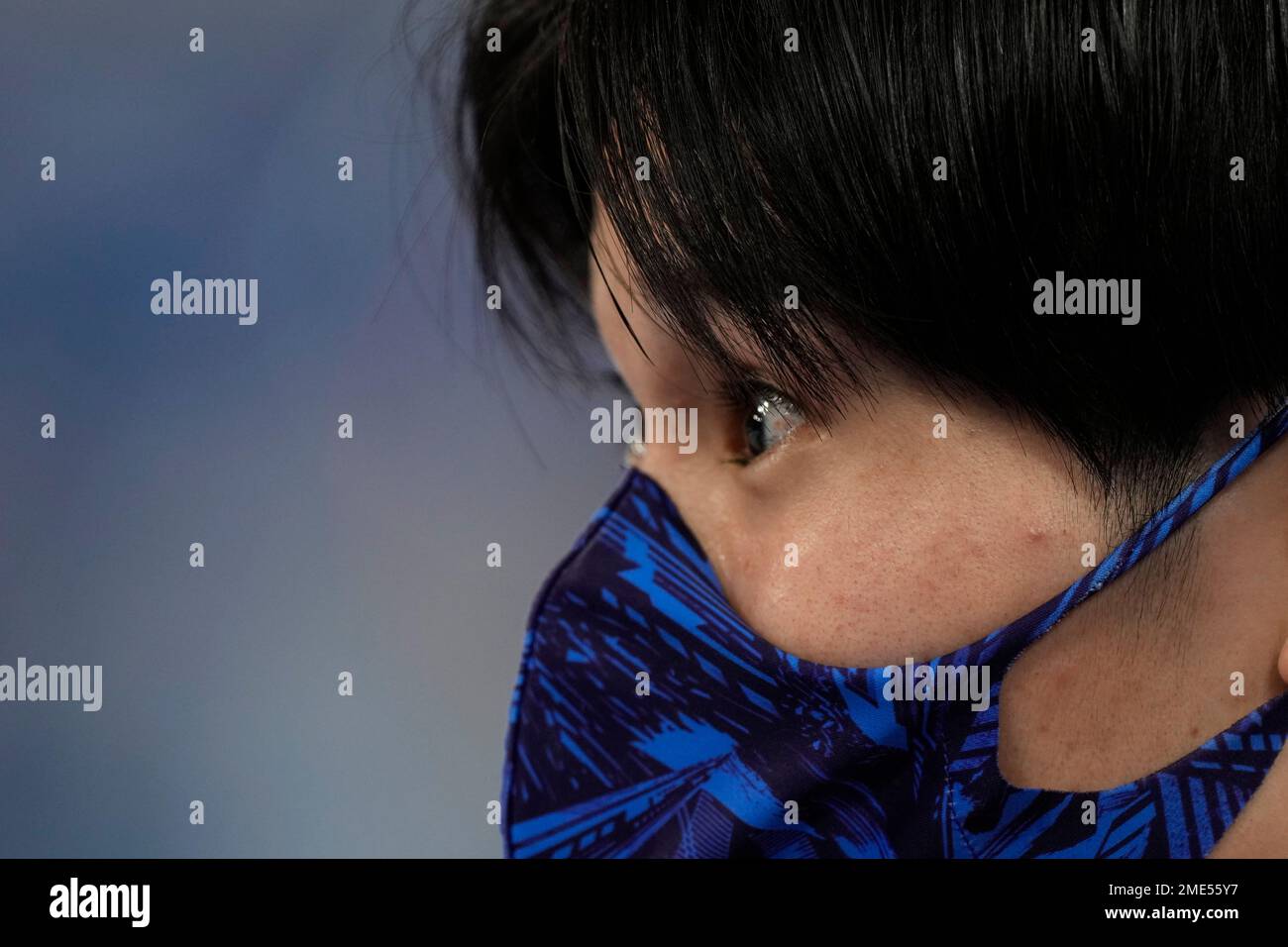 Kazuma Kaya, of Japan, wears a face mask and watches athletes perform ...